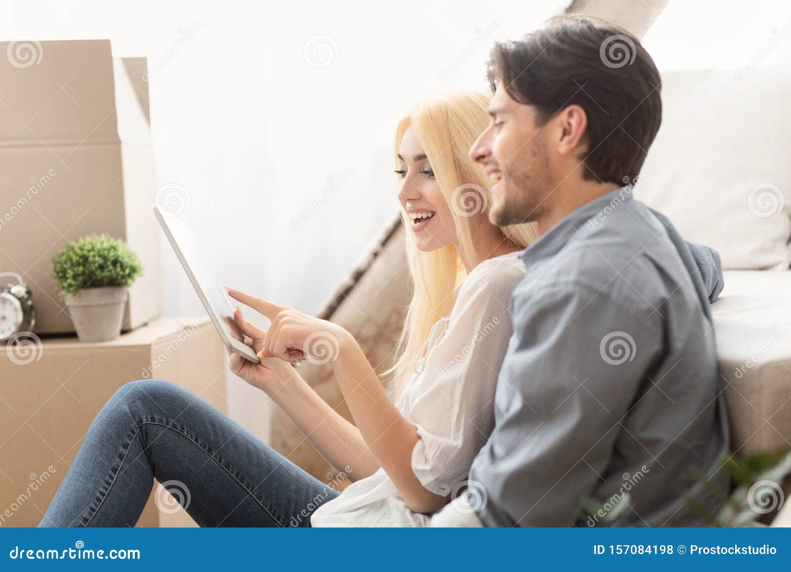 Husband and Wife Using Tablet Computer Sitting among Moving Boxes Stock ...