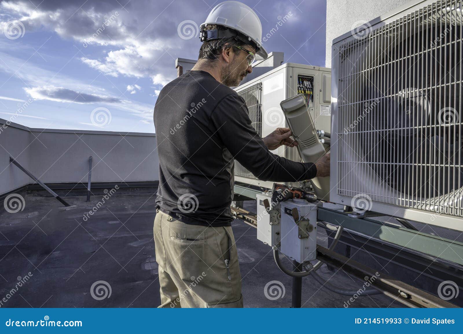 HVAC Technician Is Working On Air Conditioner Units On A Roof Of New ...