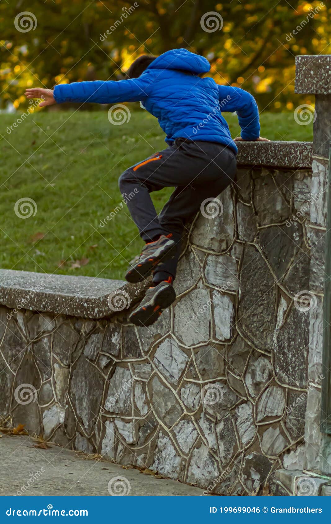 A Hyperactive Kid is Jumping Off a High Wall As he is Running Away ...