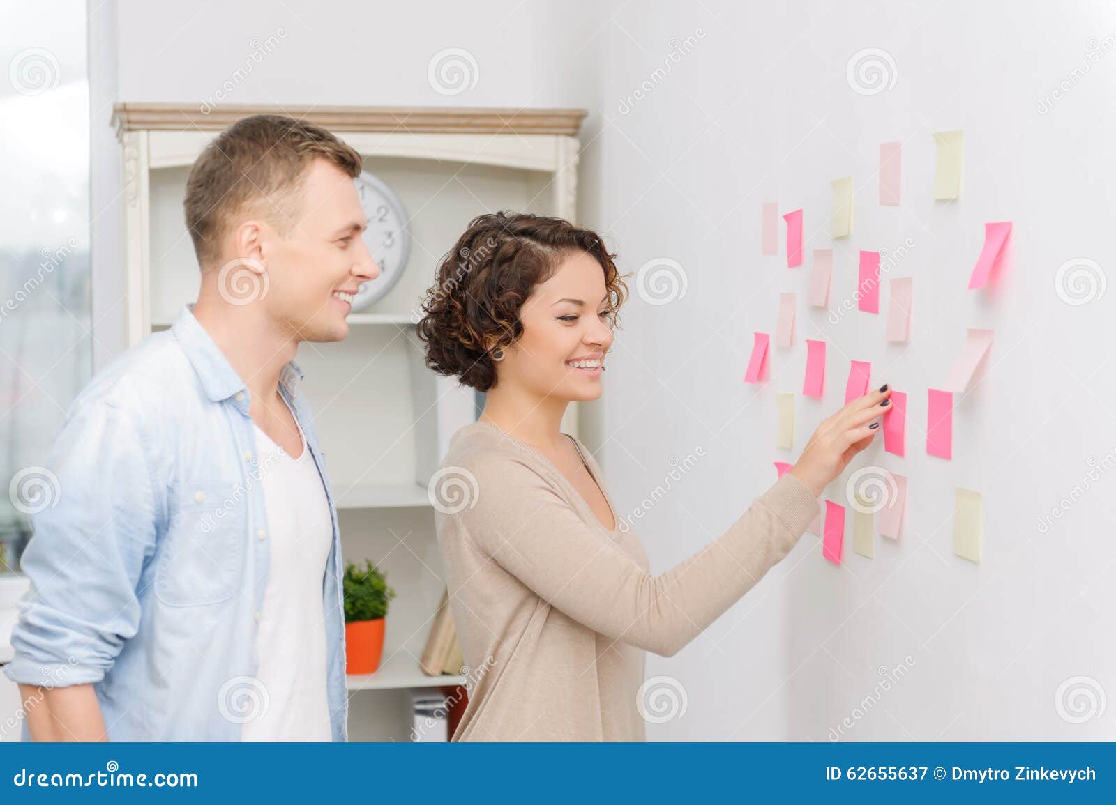 I Colleghe Stanno Attaccando Le Note Di Post-it Alla Parete Immagine ...