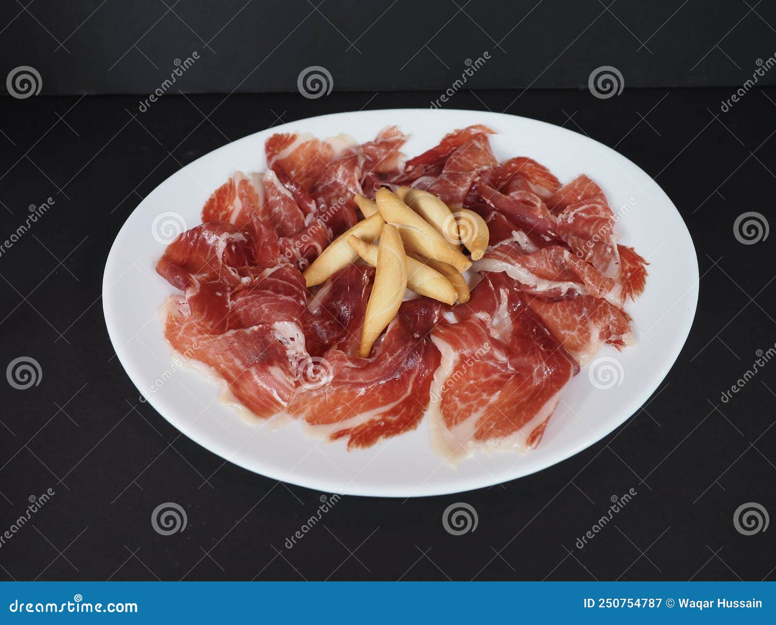 Iberico Ham with Garlic Served in a Dish Isolated on Dark Background ...
