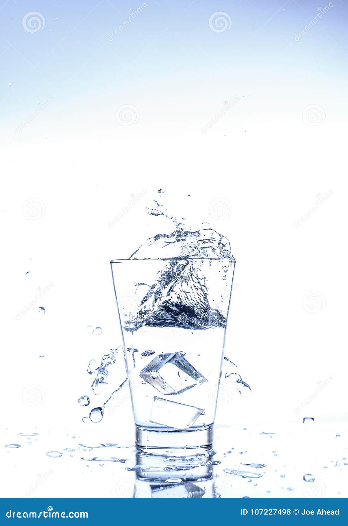 Ice Dropping and Water Splashing in the Glass with Reflection on Stock ...