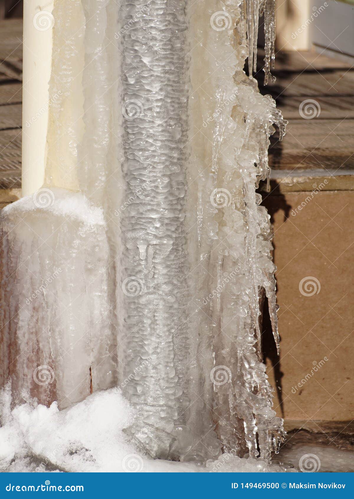 Ice and Icicles on a Drainpipe. Drainpipe Covered with Ice and Icicles ...