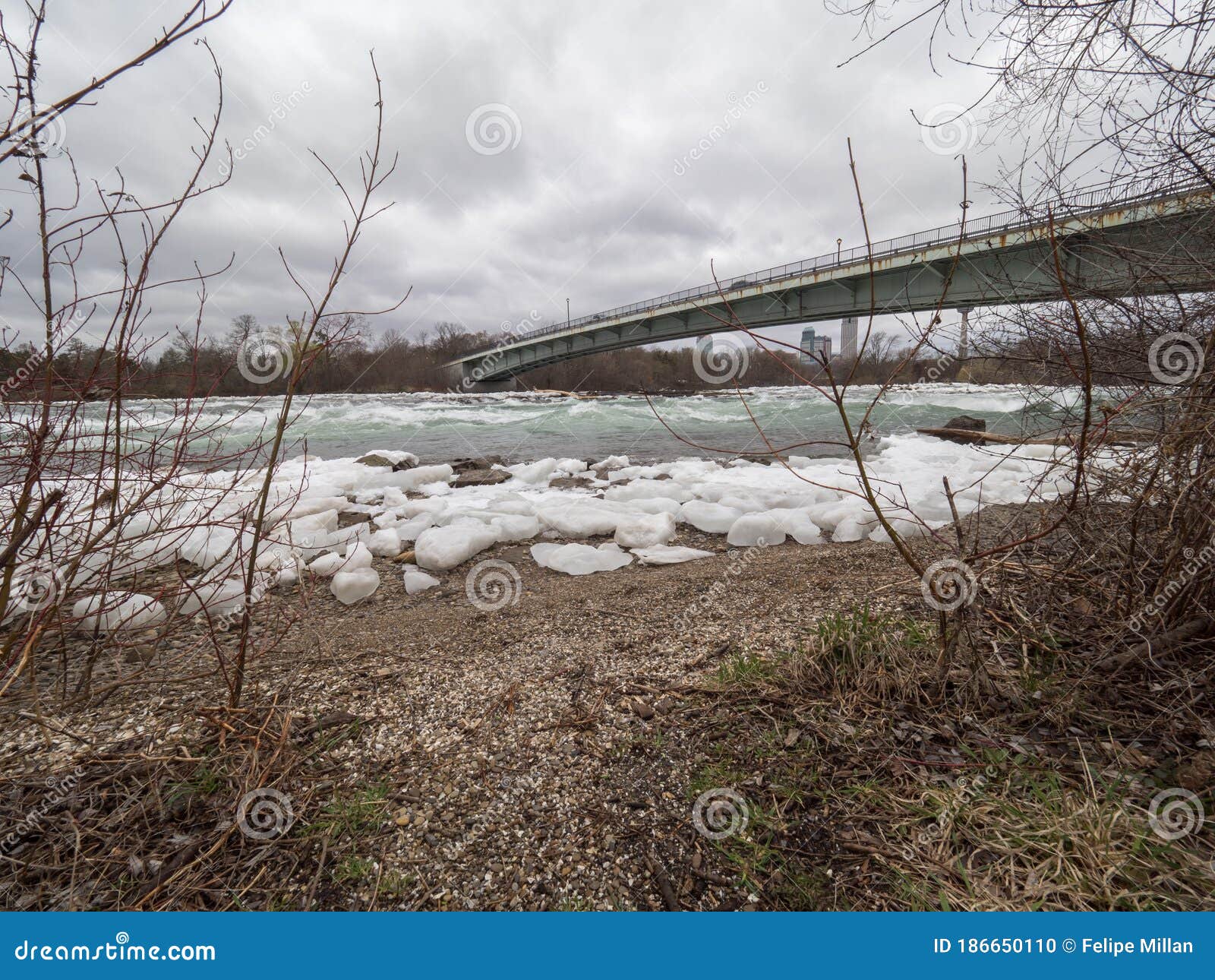 Ice Rocks on the Niagara River Shore, Bridge Over Water Stock Photo ...