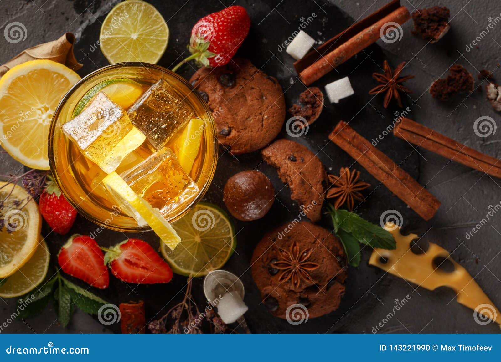 Ice Tea in a Glass on a Black Plate with Biscuits, Sweets and Fruits on ...