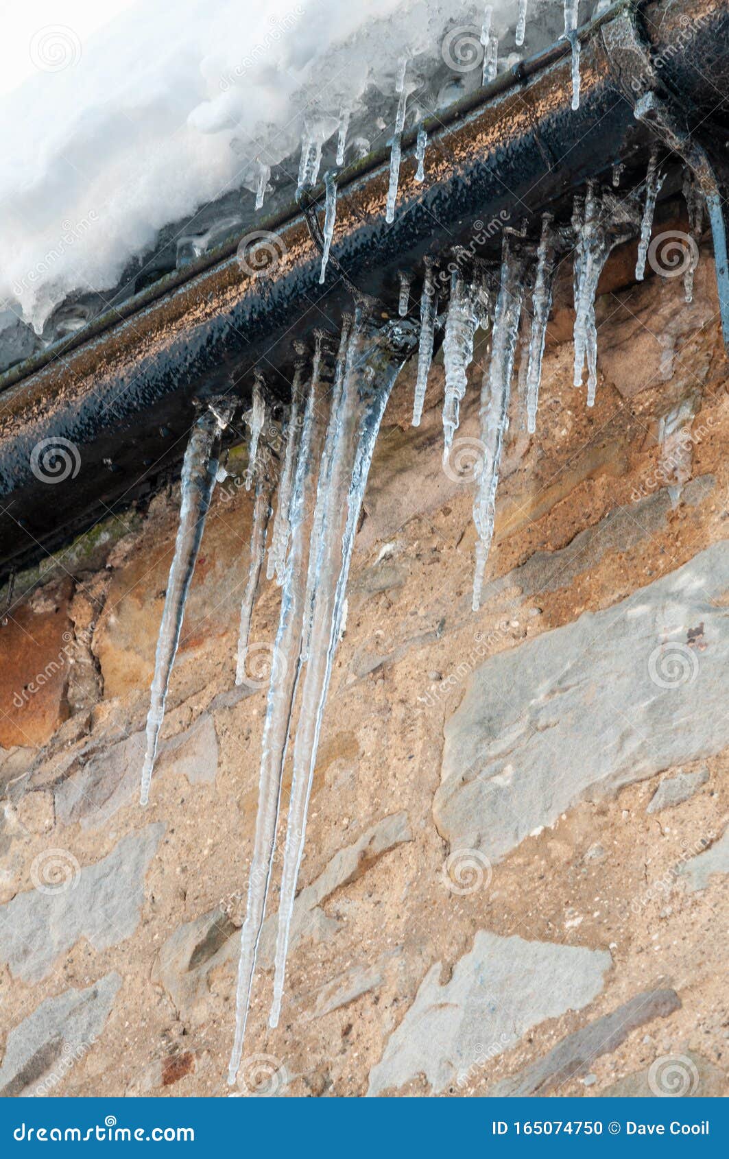 Icicles Hanging from Guttering on a Stone Wall Stock Photo - Image of ...