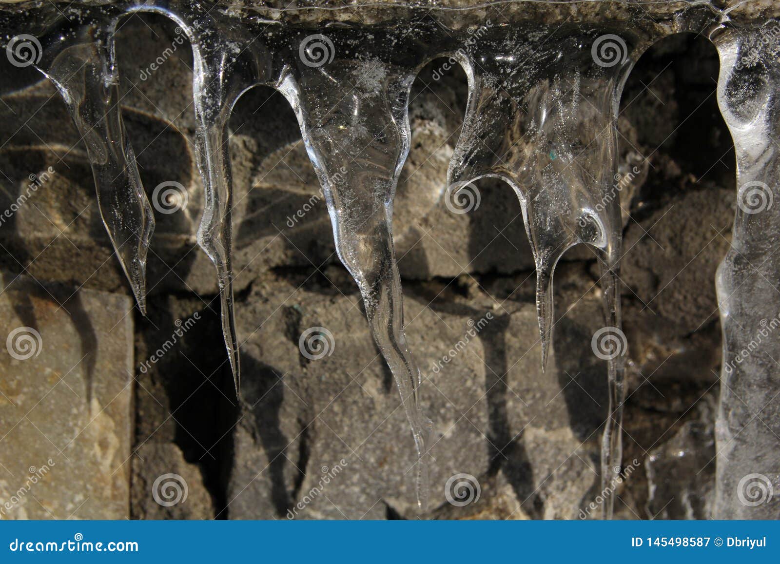Icicles Hanging on a Ledge with Rocky Bacground Stock Image - Image of ...