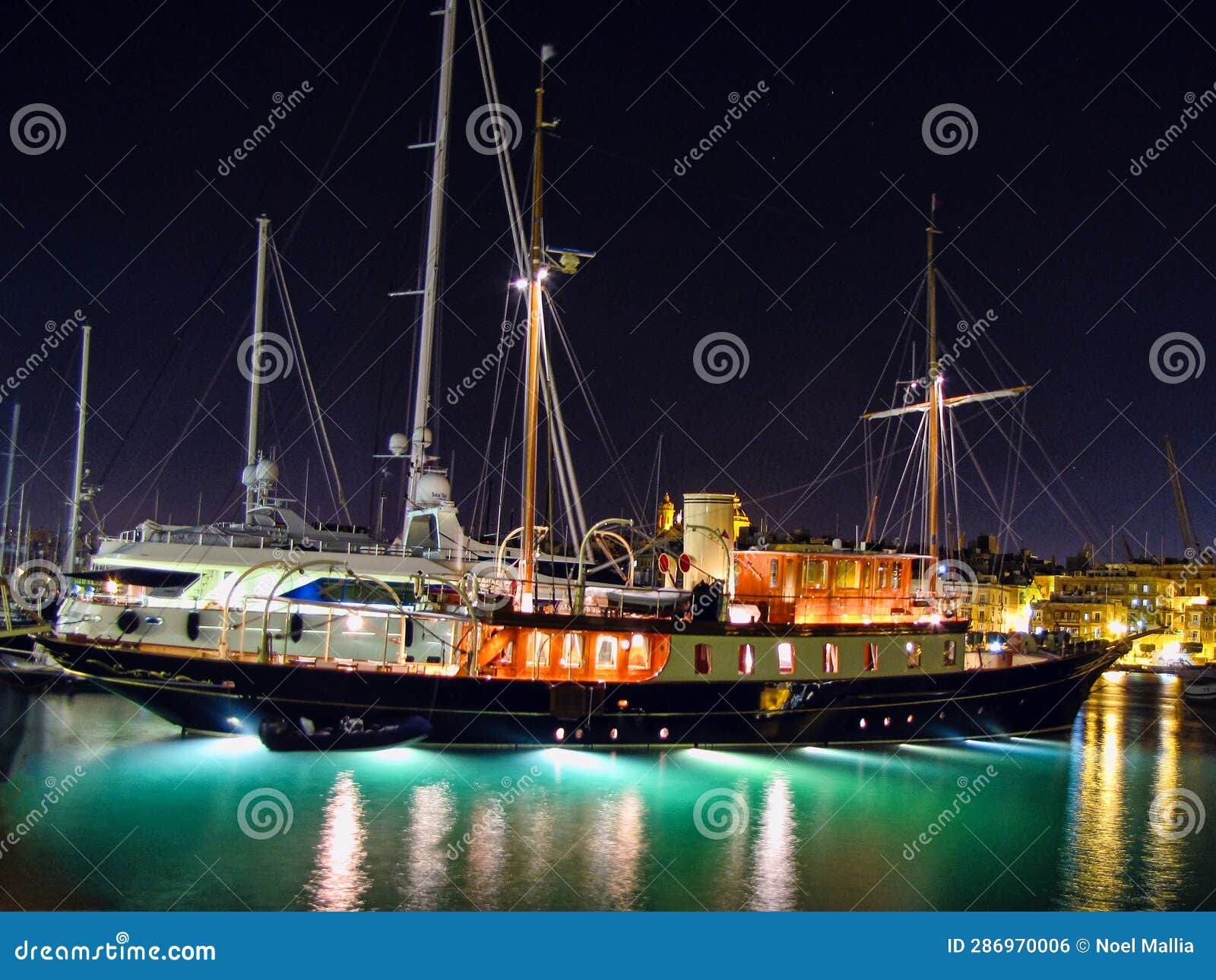 Illuminated Sailboat at Dusk on Harbor Dock Stock Photo - Image of ...