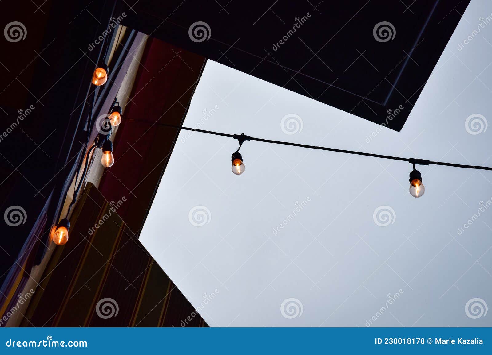 Illuminated Edison Light Bulbs on Wire Against Building Angles Stock ...
