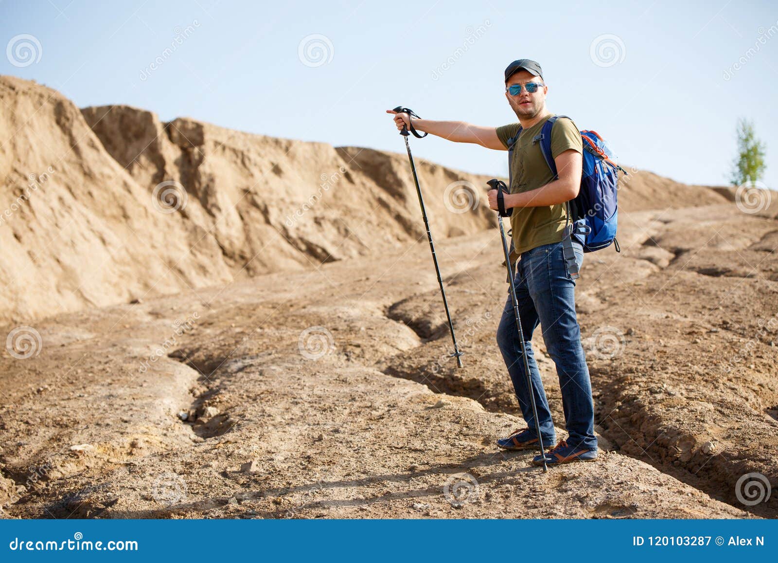 Image of Athlete Man with Backpack and Walking Sticks Pointing with ...