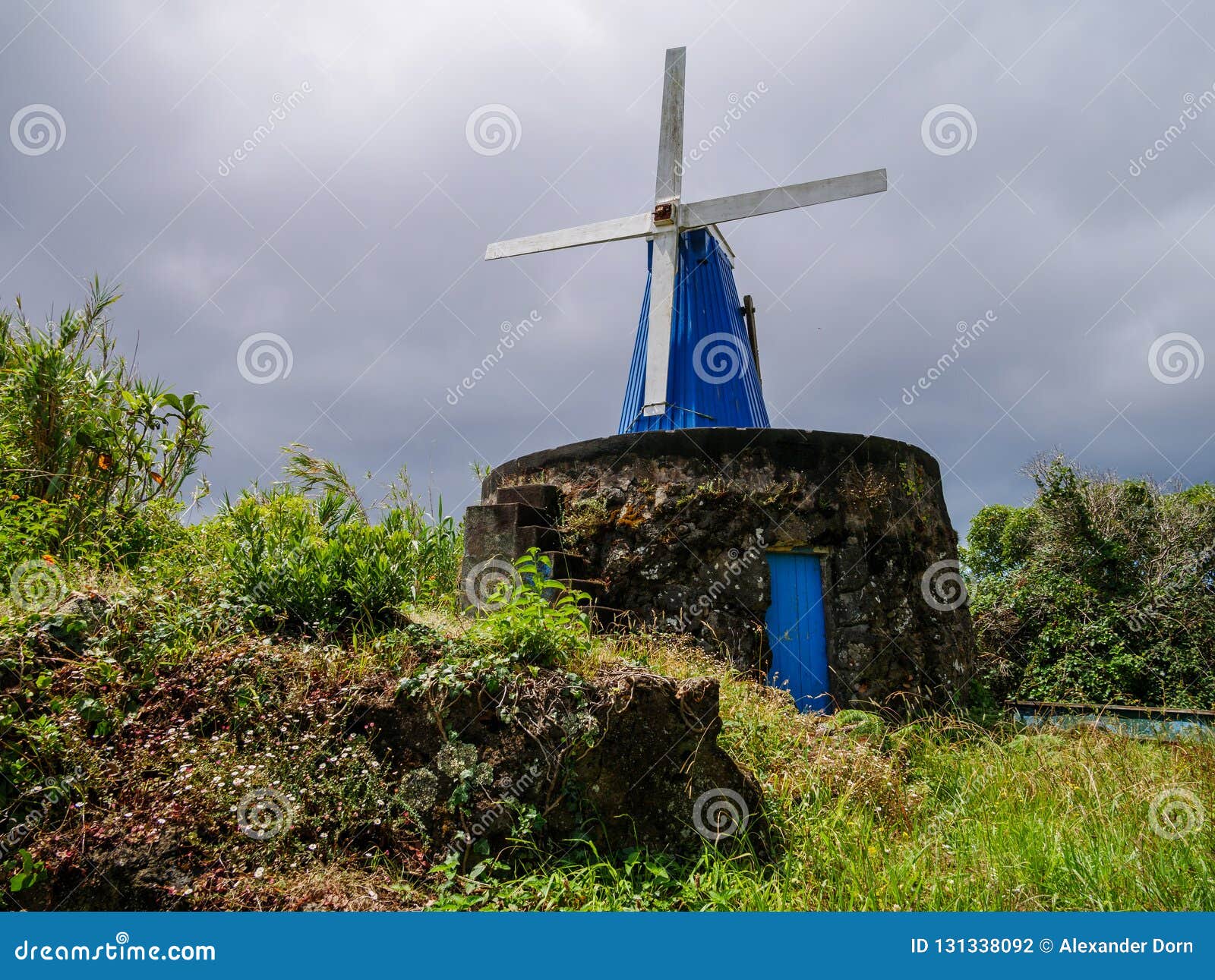 Image of Blue Wooden Wind Mill on a Stone Base Stock Photo - Image of ...