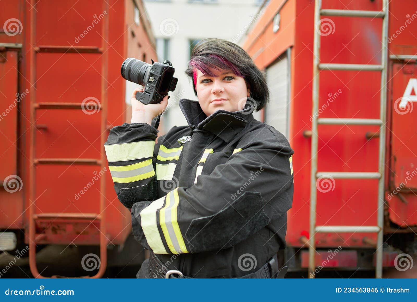 Image of Brunette Firefighter with Camera at Hand Standing Next To ...