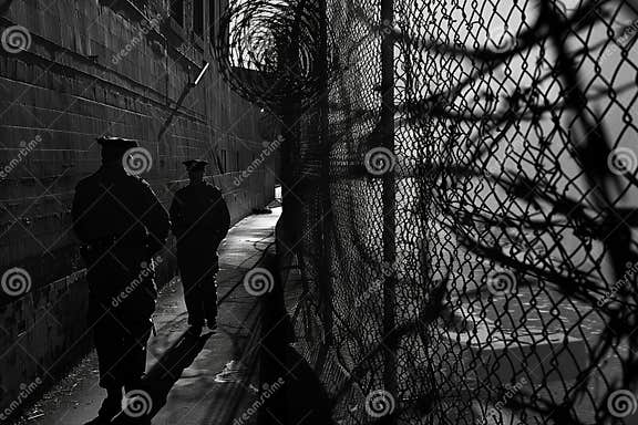 Prison Yard Security: Two Guards Patrolling Inside Razor Wire-enclosed ...