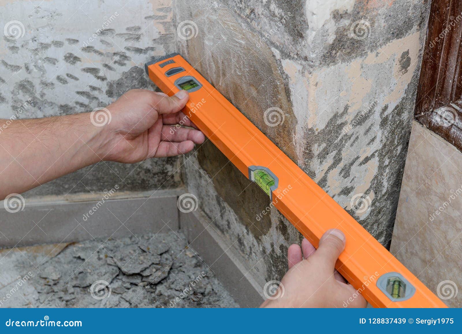 Construction Work, a Worker Measures the Wall by Building Level Stock ...