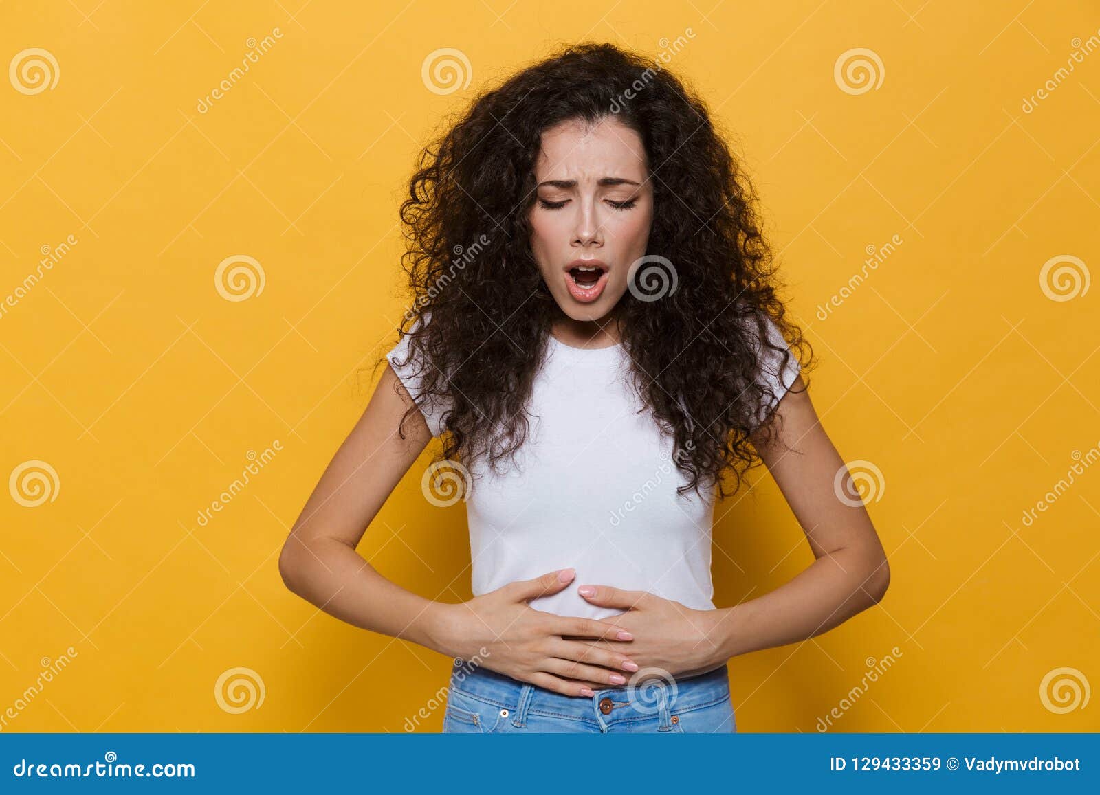 Image Of Displeased Woman 20s With Curly Hair Touching Stomach A Stock