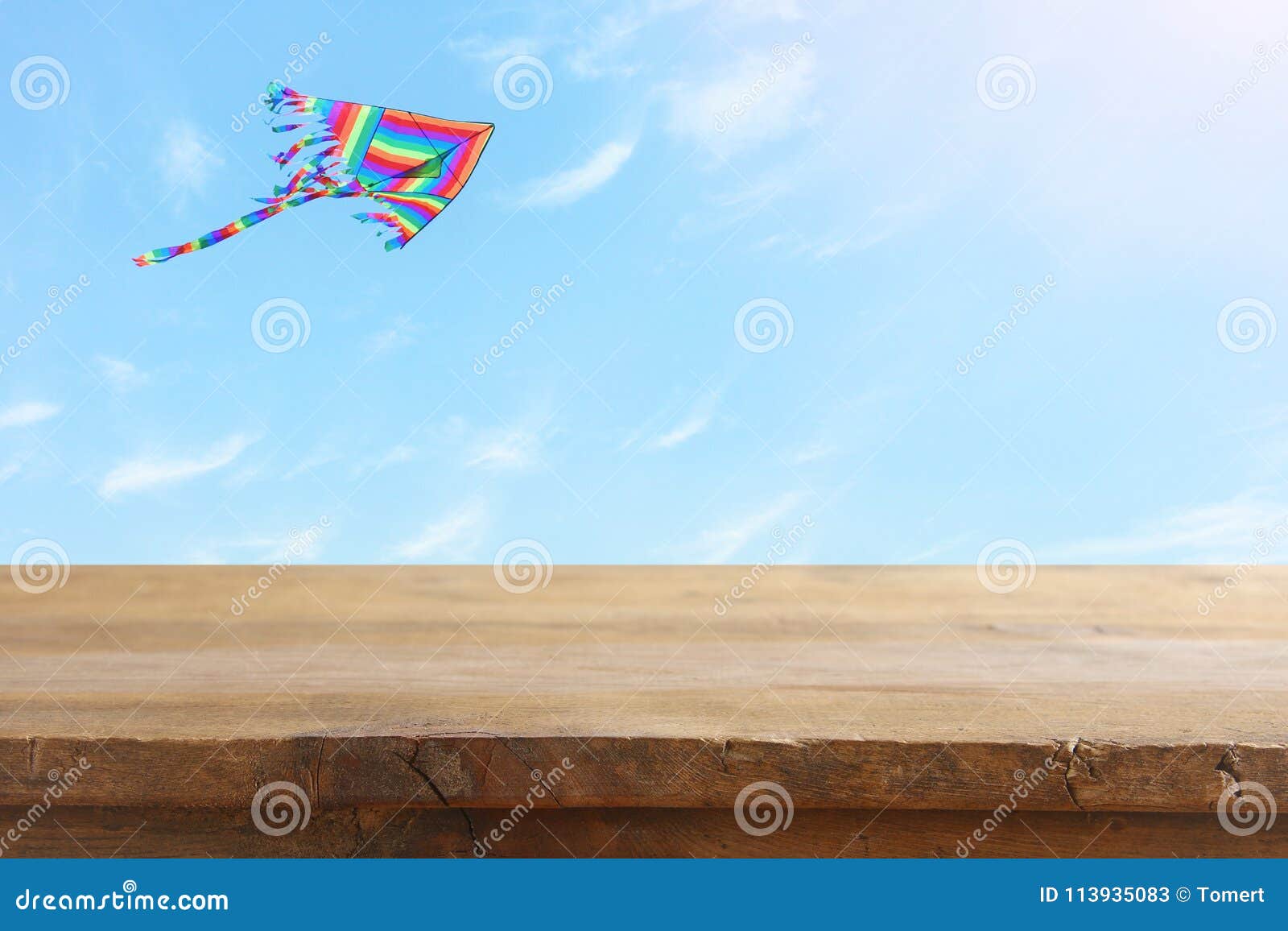 Image of Empty Rustic Table in Front of Colorful Kite Flying in the ...