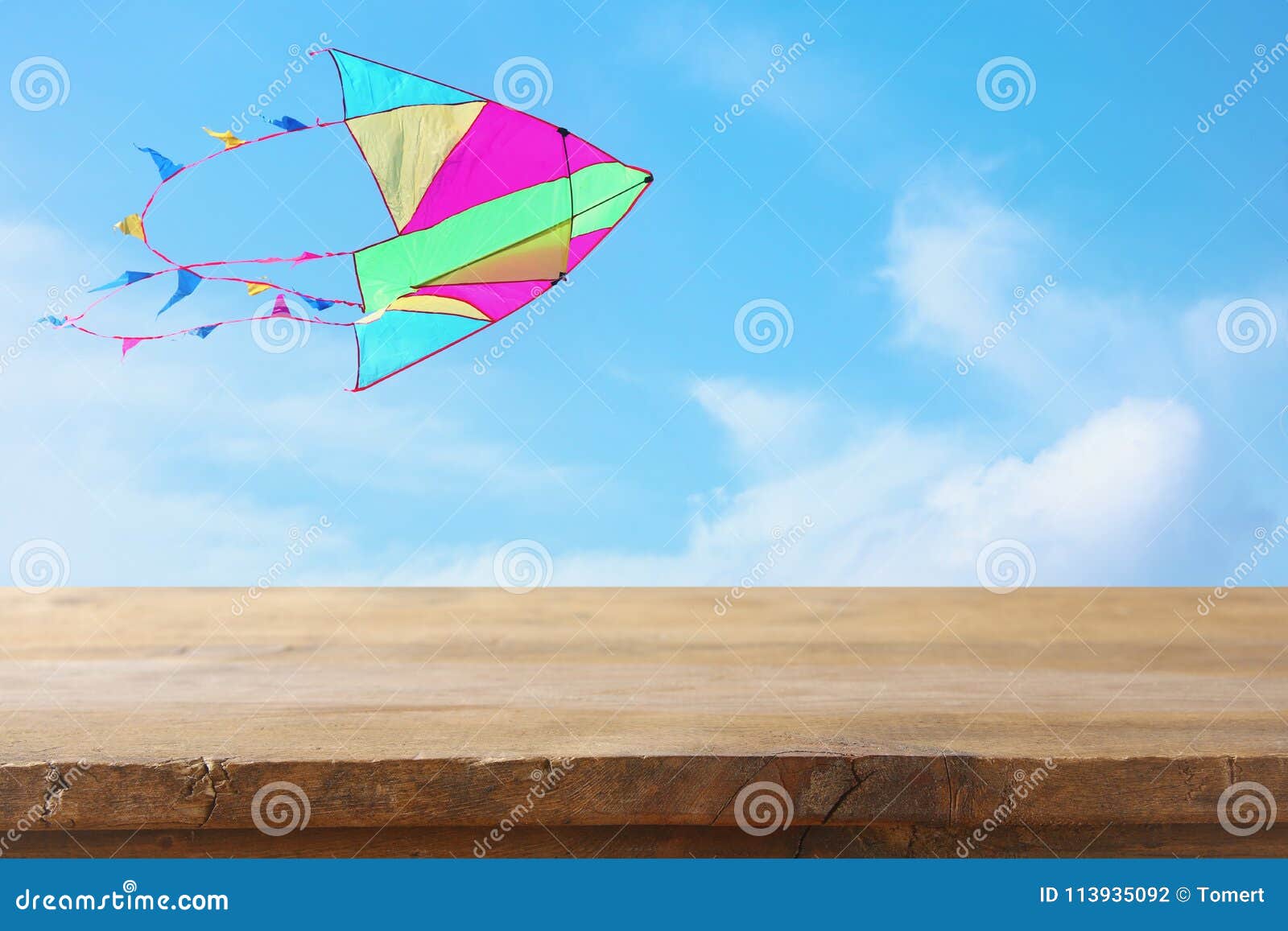 Image of Empty Rustic Table in Front of Colorful Kite Flying in the ...