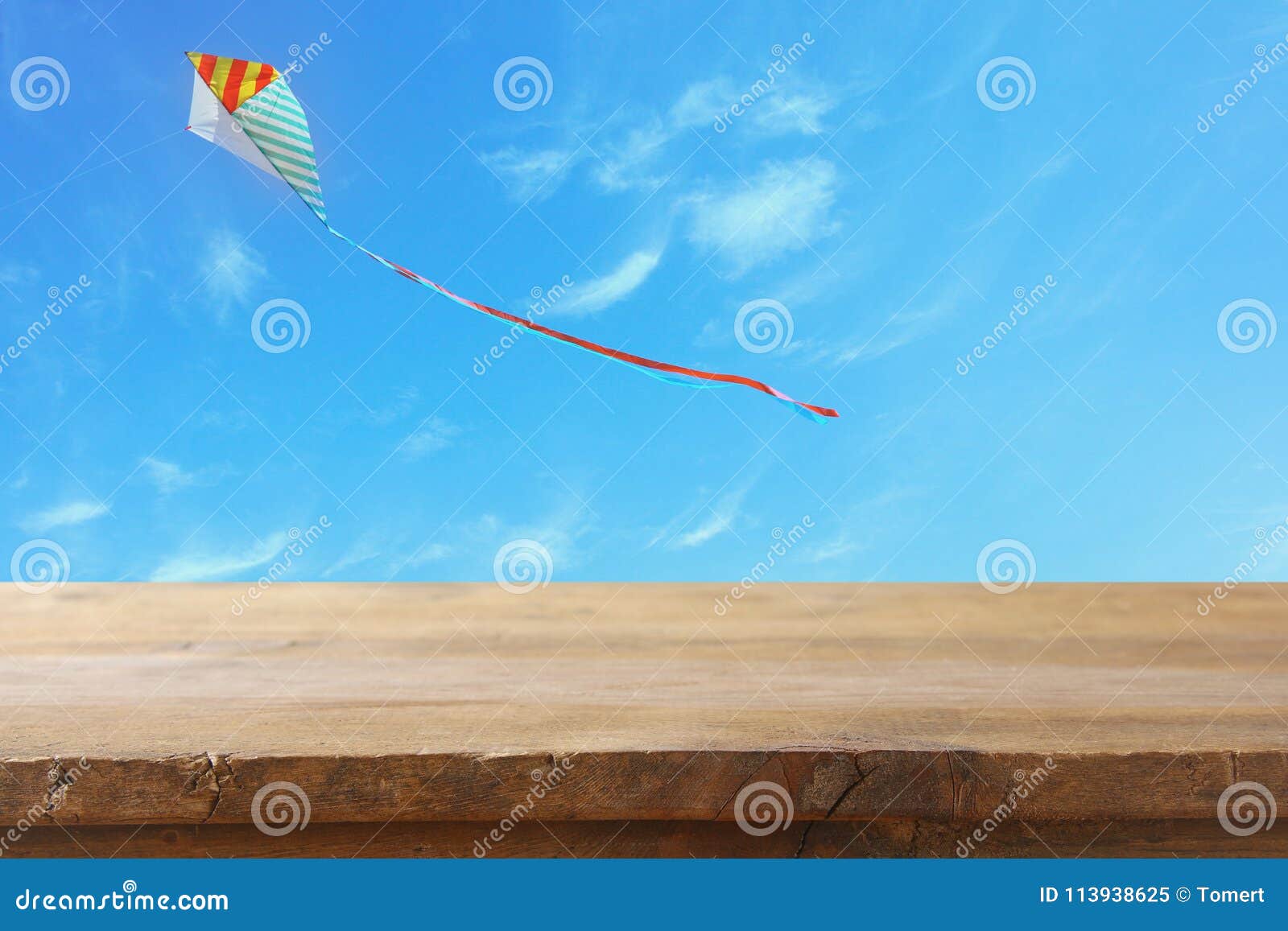 Image of Empty Rustic Table in Front of Colorful Kite Flying in the ...