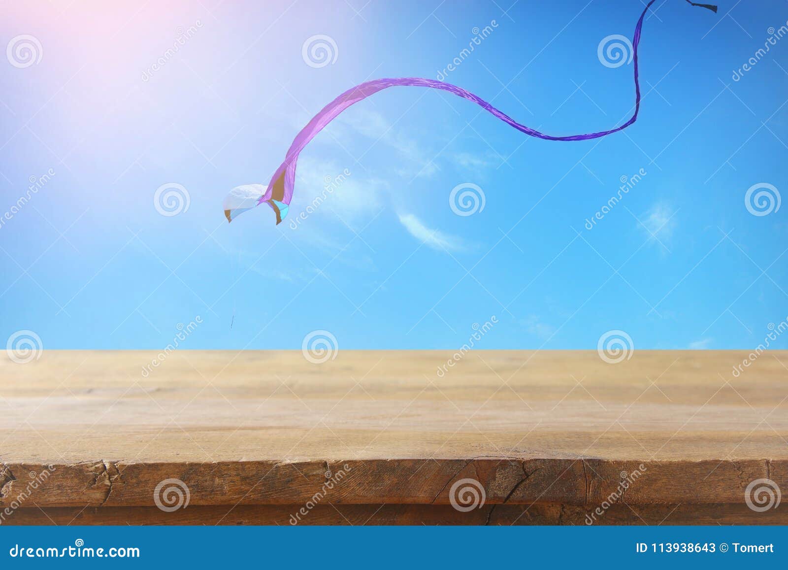 Image of Empty Rustic Table in Front of Colorful Kite Flying in the ...