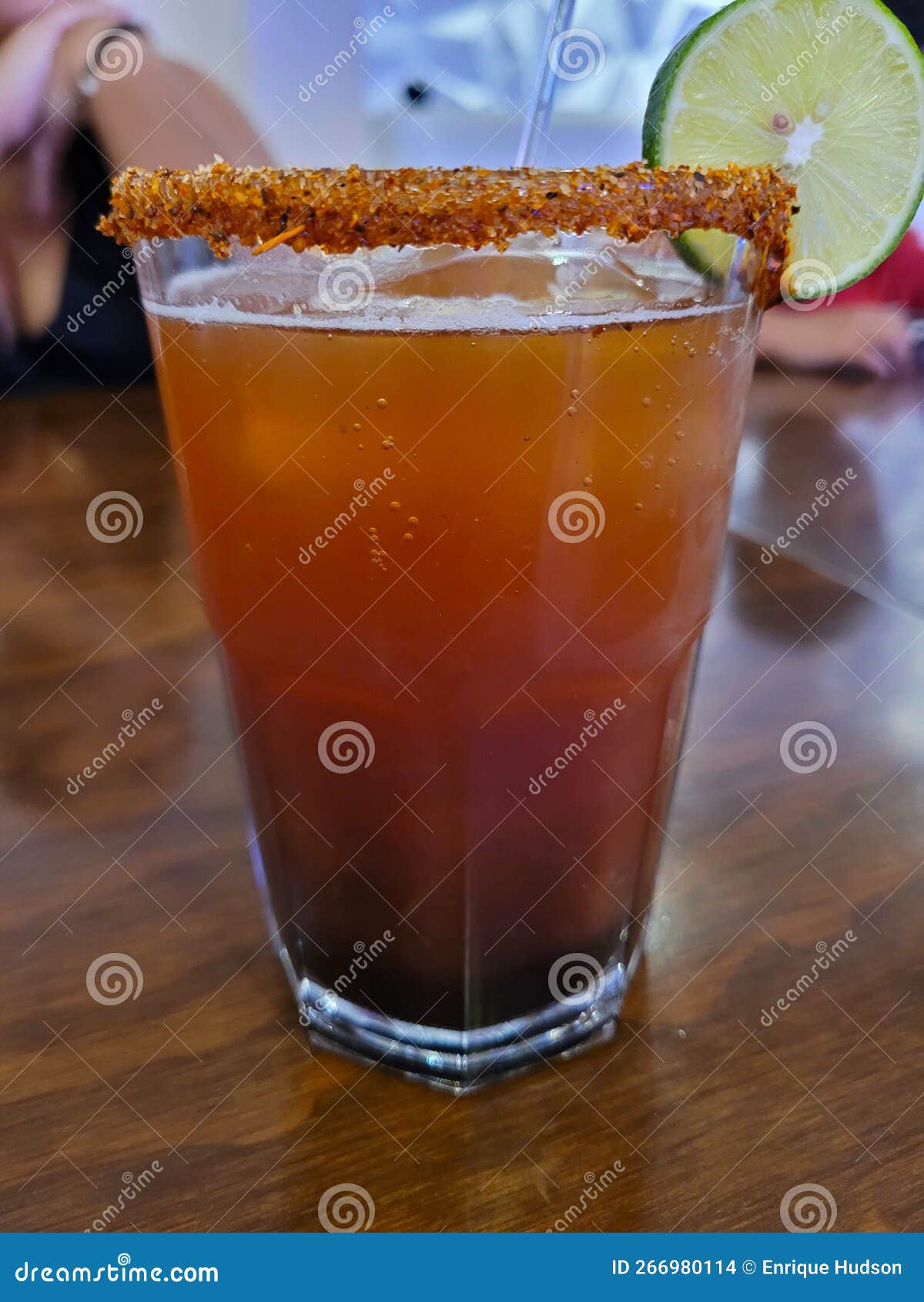 An Image of a Glass of Michelada with a Slice of Lime on a Wooden Table ...