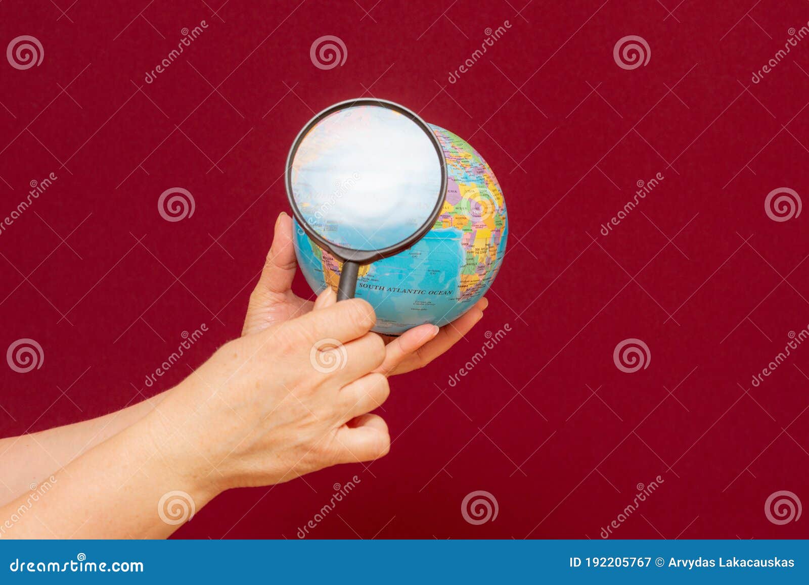 Image of a Hand Holding a Magnifying Glass Over an World Globe Stock ...