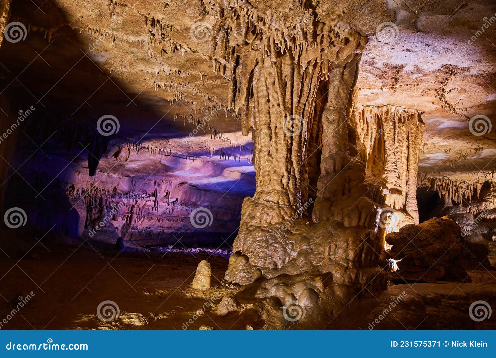 Large Rock Formations in Cave with Waxy Surface and Glow of Purple in ...