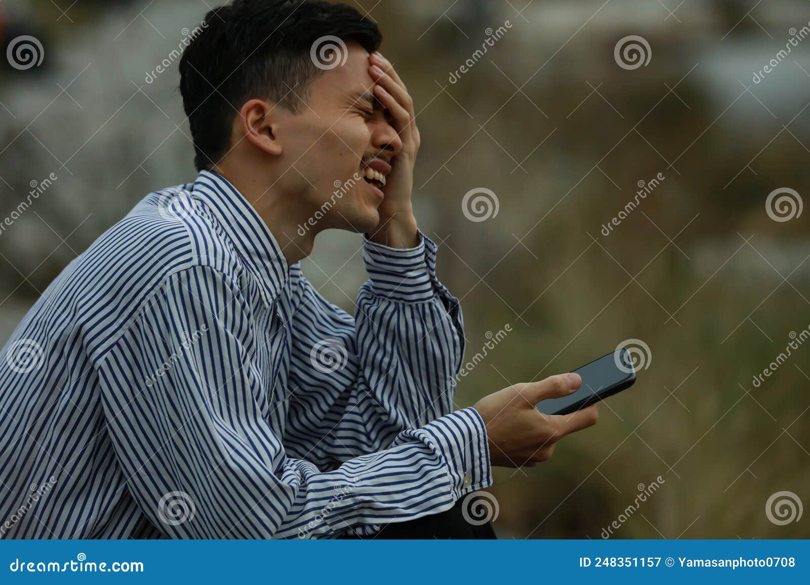 A Man Holding a Smartphone and Distorting His Face Stock Image - Image ...