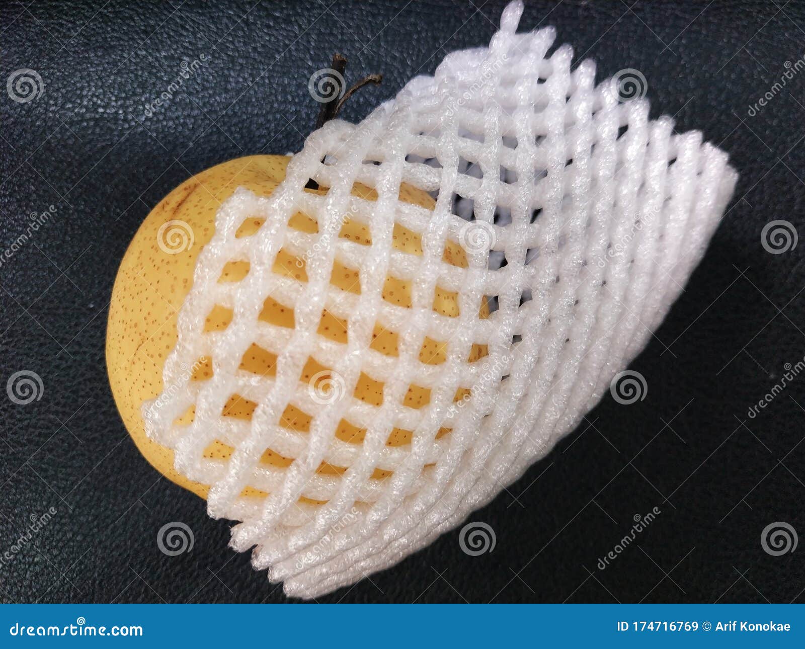 Pear Fruit Wrapped in a Fruit Net on a Black Leather Board Stock Image ...