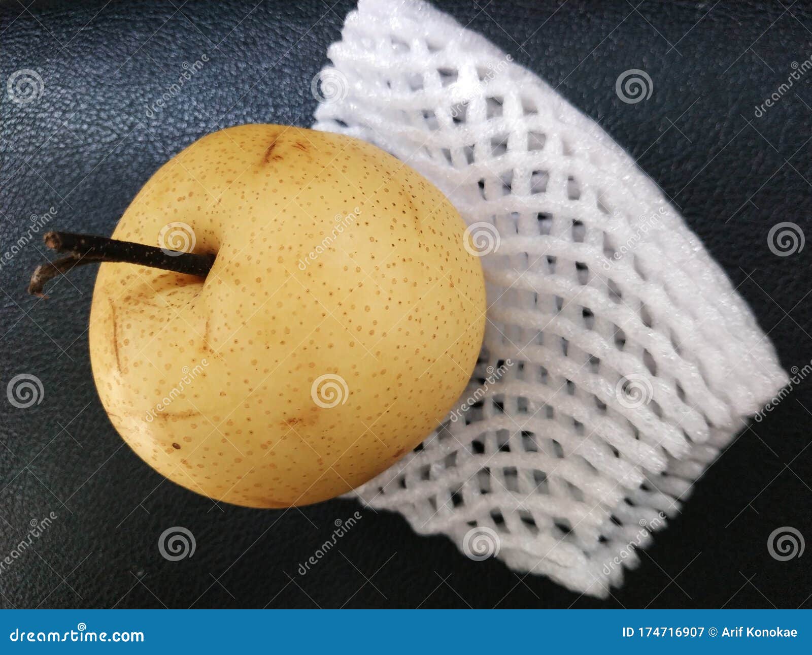 Pear Fruit Wrapped in a Fruit Net on a Black Leather Board Stock Image ...