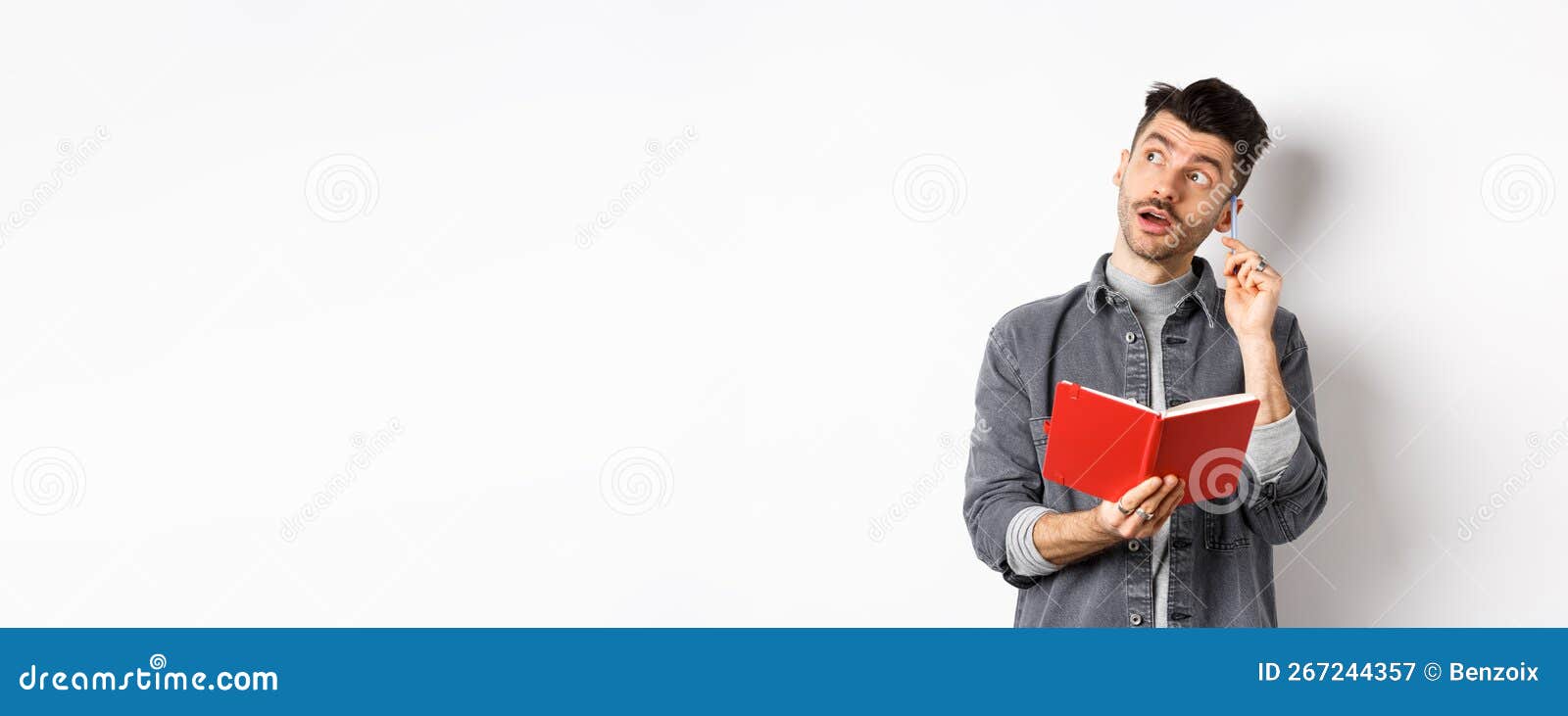 Image of Pensive Young Man Writing Down Ideas in Planner, Looking ...