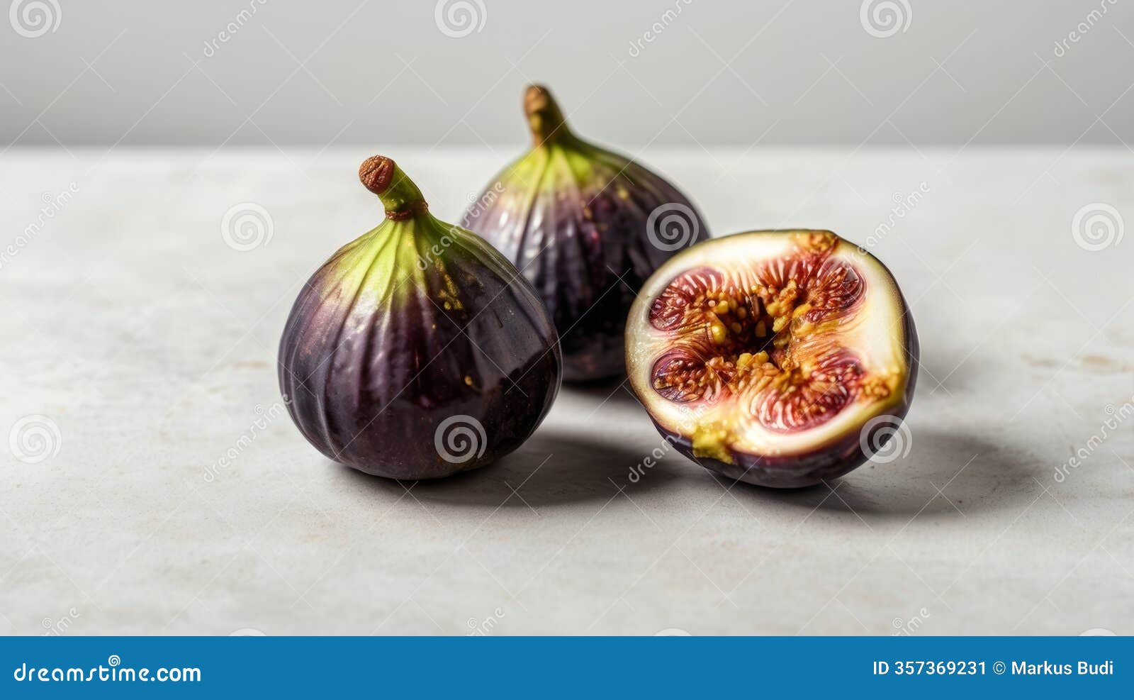 Three Fresh Figs on a Textured Surface with One Fig Cut Open Revealing ...