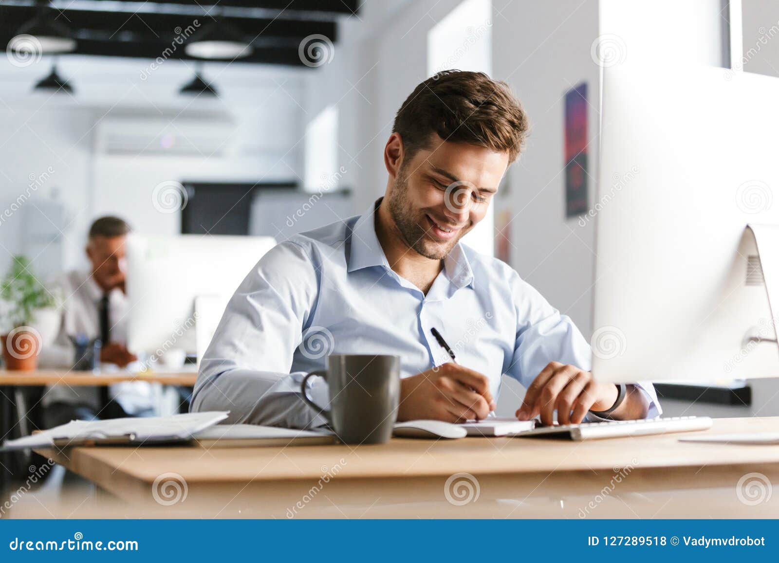 Image of Smiling Male Manager Writing Something Stock Photo - Image of ...