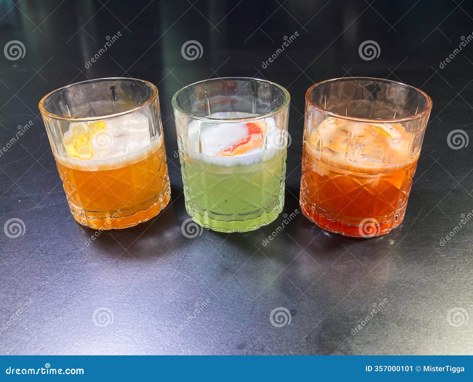 Image of Three Drinks, Each Presented in a Clear Glass on a Reflective ...