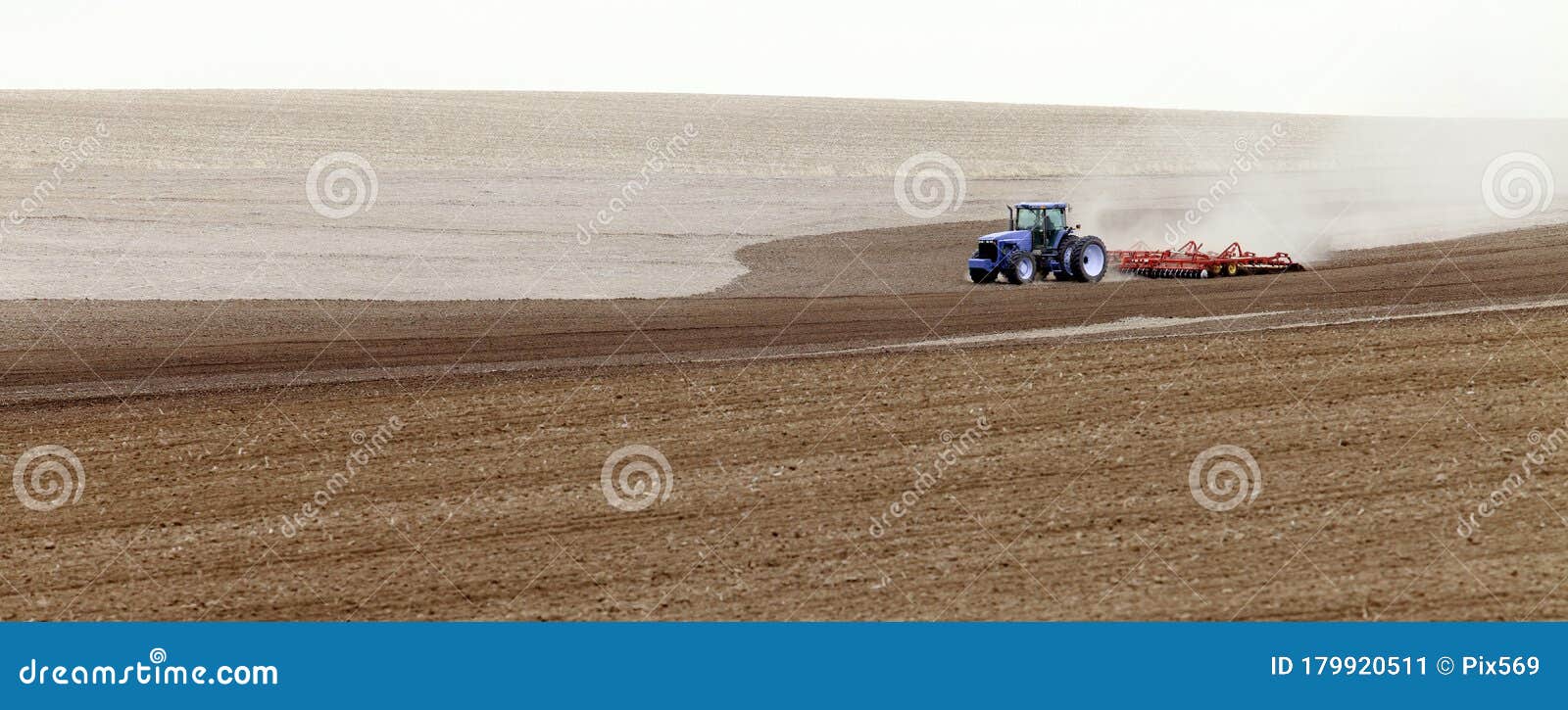 A Tractor Pulling a Plowing Implement, Plows an Idaho Farm Field Stock ...