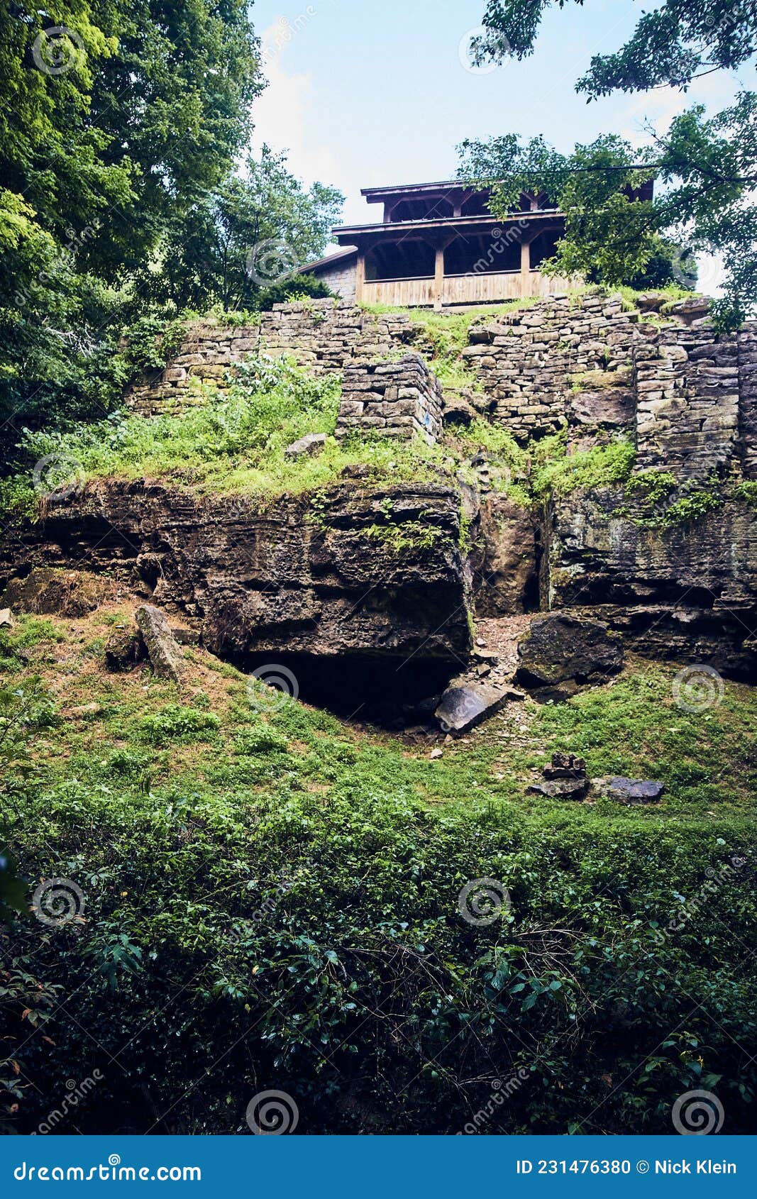 Vertical of Structure with Stone Wall on Stone Cliffs Next To Green ...