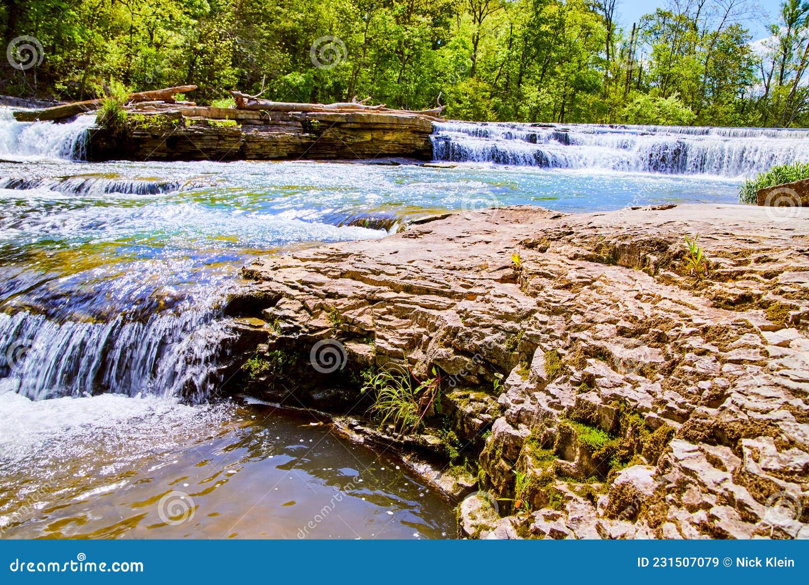 Waterfalls through River with Bumpy Rocks and Green Forest Stock Image ...