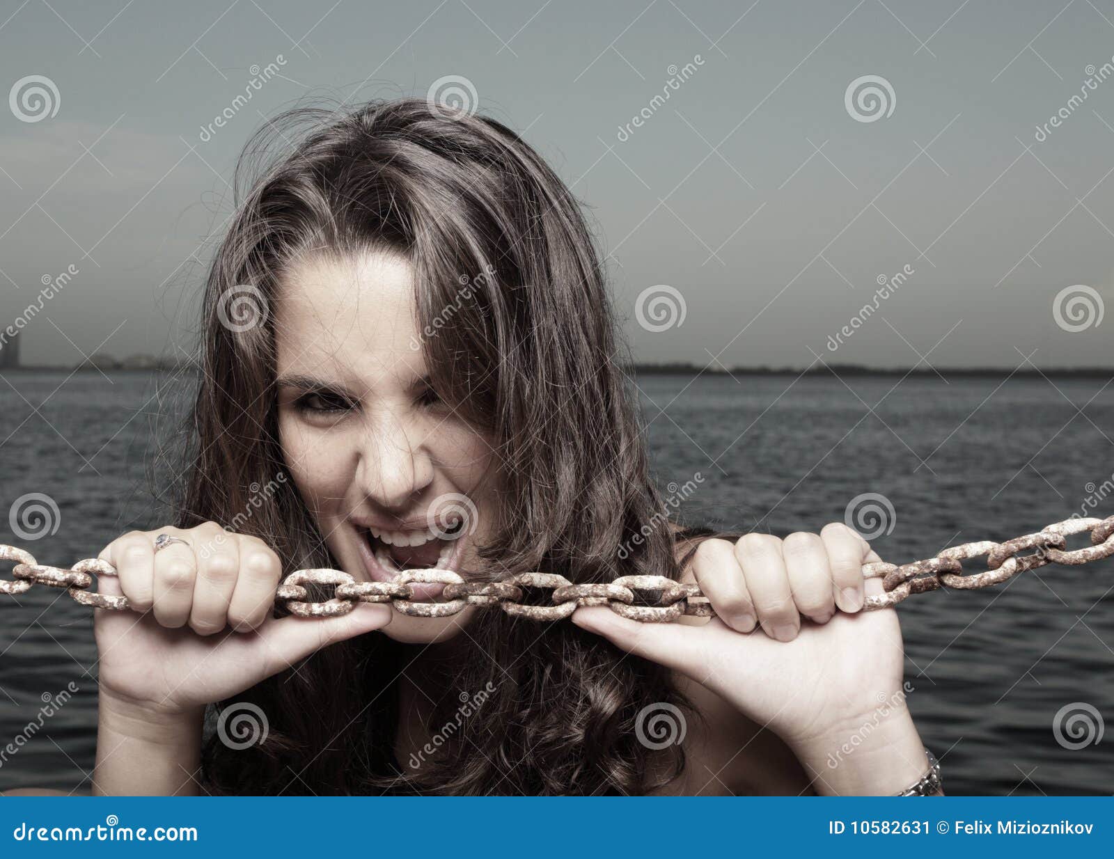 Image of a Woman Biting a Chain Stock Image - Image of blue, horizon ...