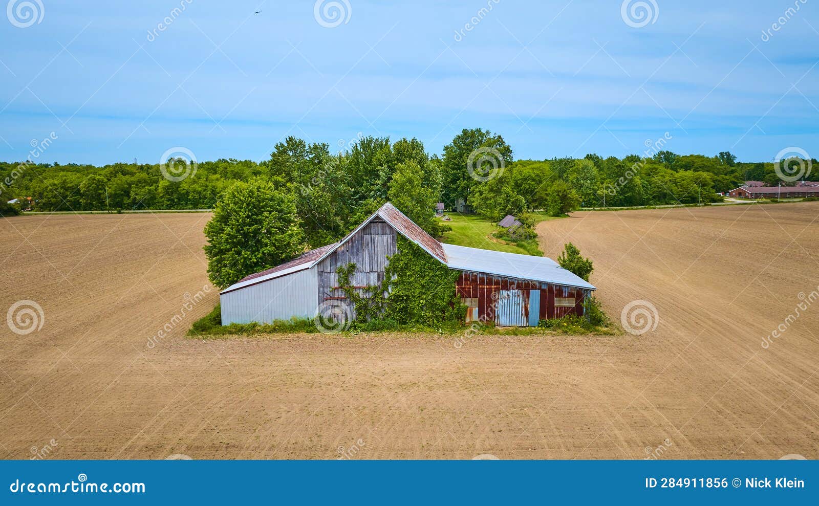 Wooden and Metal Barn Rusting with Three Empty Dirt Fields and a Patch ...
