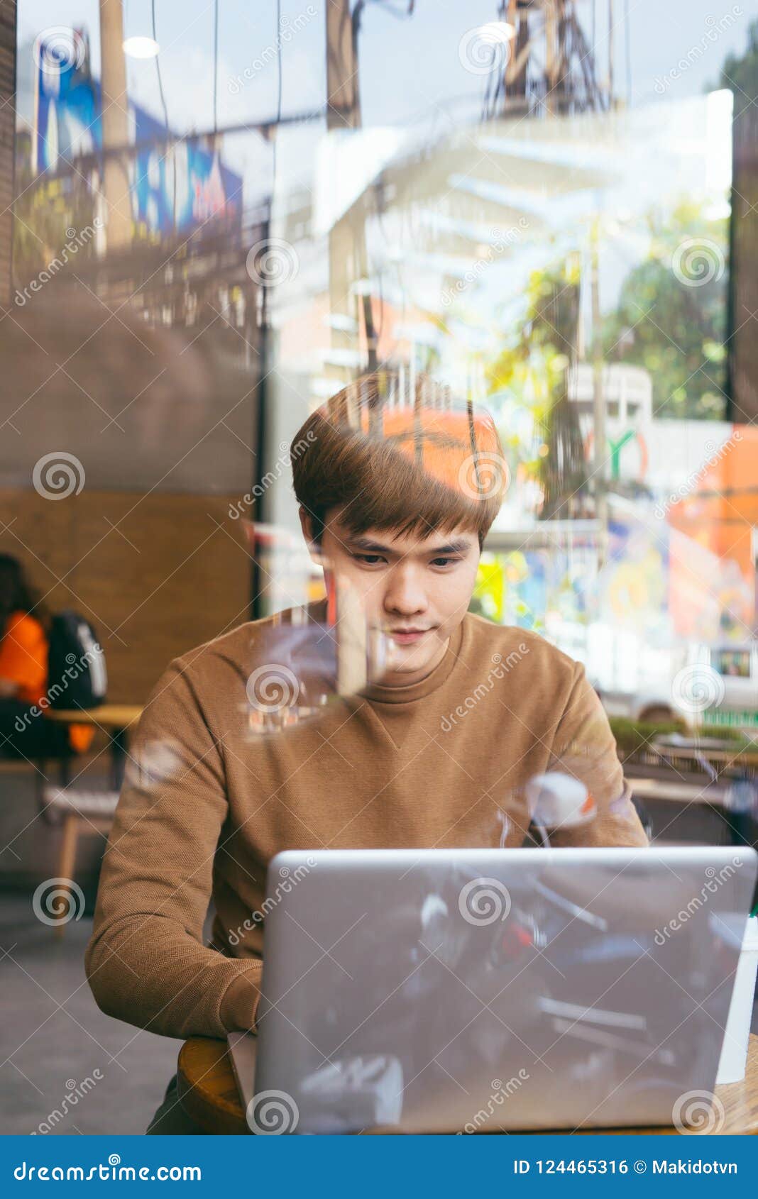Image of a Young Guy Drinking Coffee while Computing at a Student Cafe ...