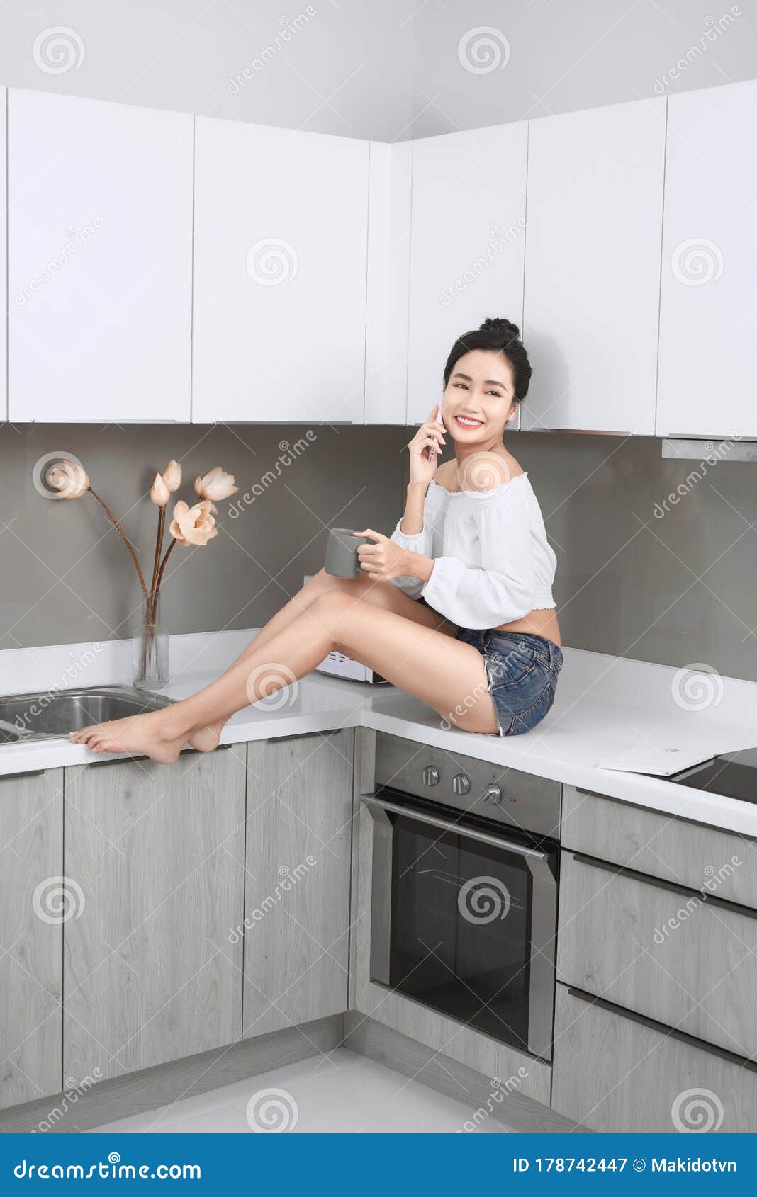 Image of a Young Happy Pretty Woman Sitting Indoors at Home at the ... Image of a Young Happy Pretty Woman Sitting Indoors at Home at the ...