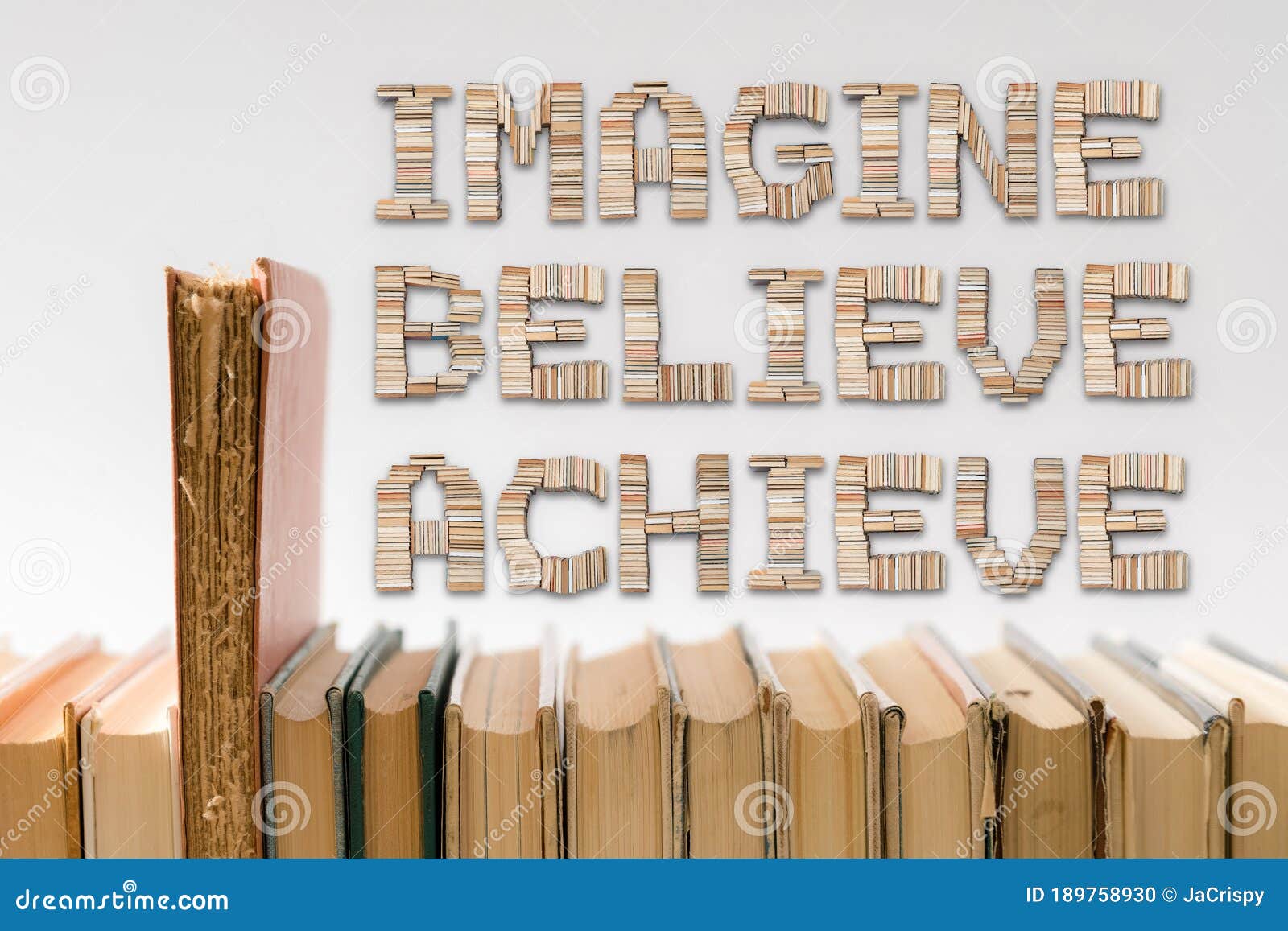 Imagine, Believe, Achieve Text with Hardback Books on the Table. Back ...