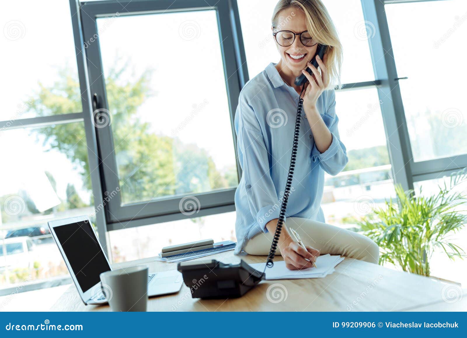 Pleasant Woman Talking on Phone and Putting Down Information Stock ...