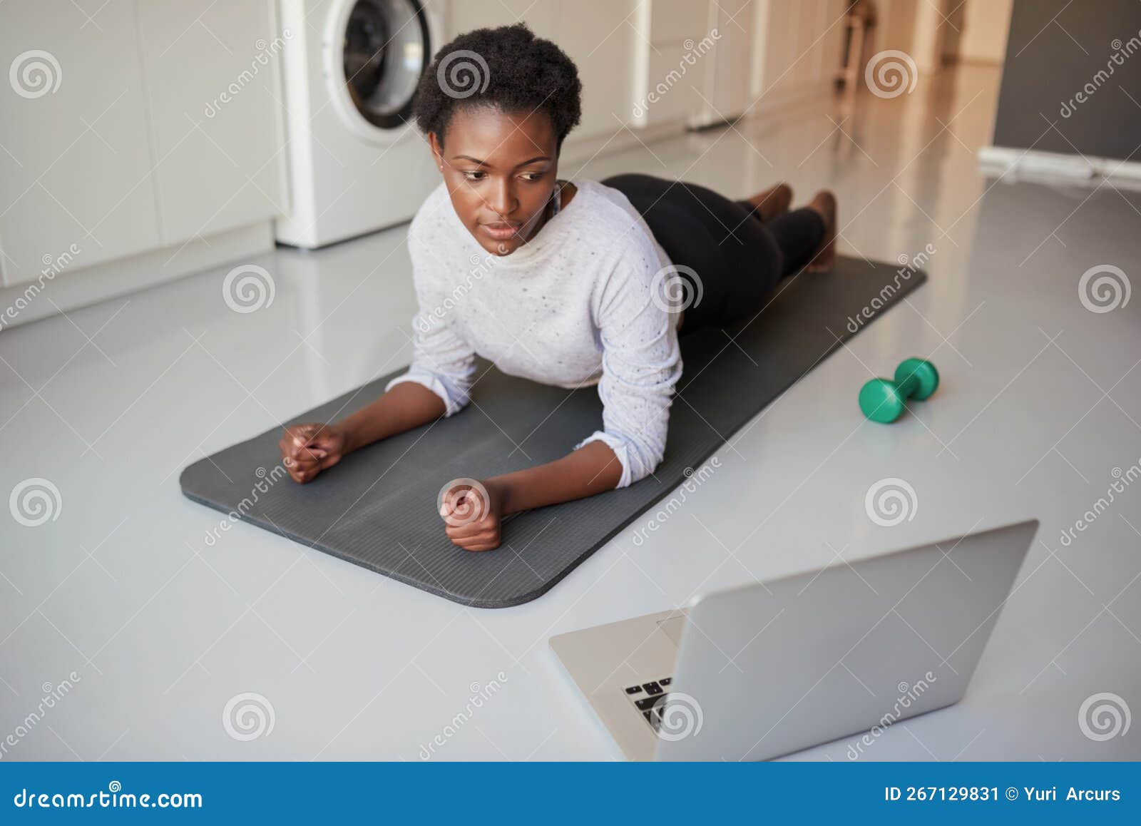Improving Her Core Strength and Stability. a Young Woman Using a Laptop ...