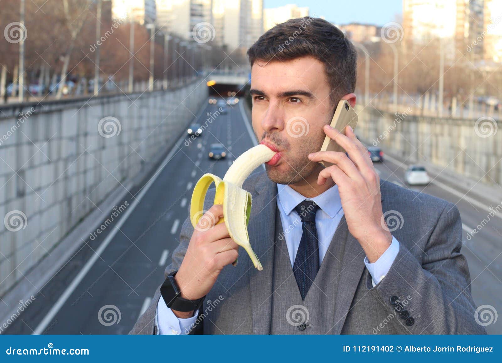 Inappropriate Man Biting a Banana while Calling Stock Photo - Image of ...