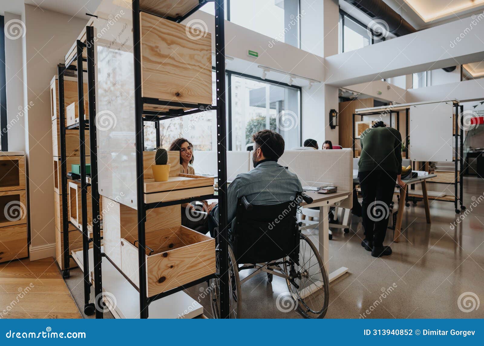 Diverse Office Setting Featuring a Wheelchair User Working with ...