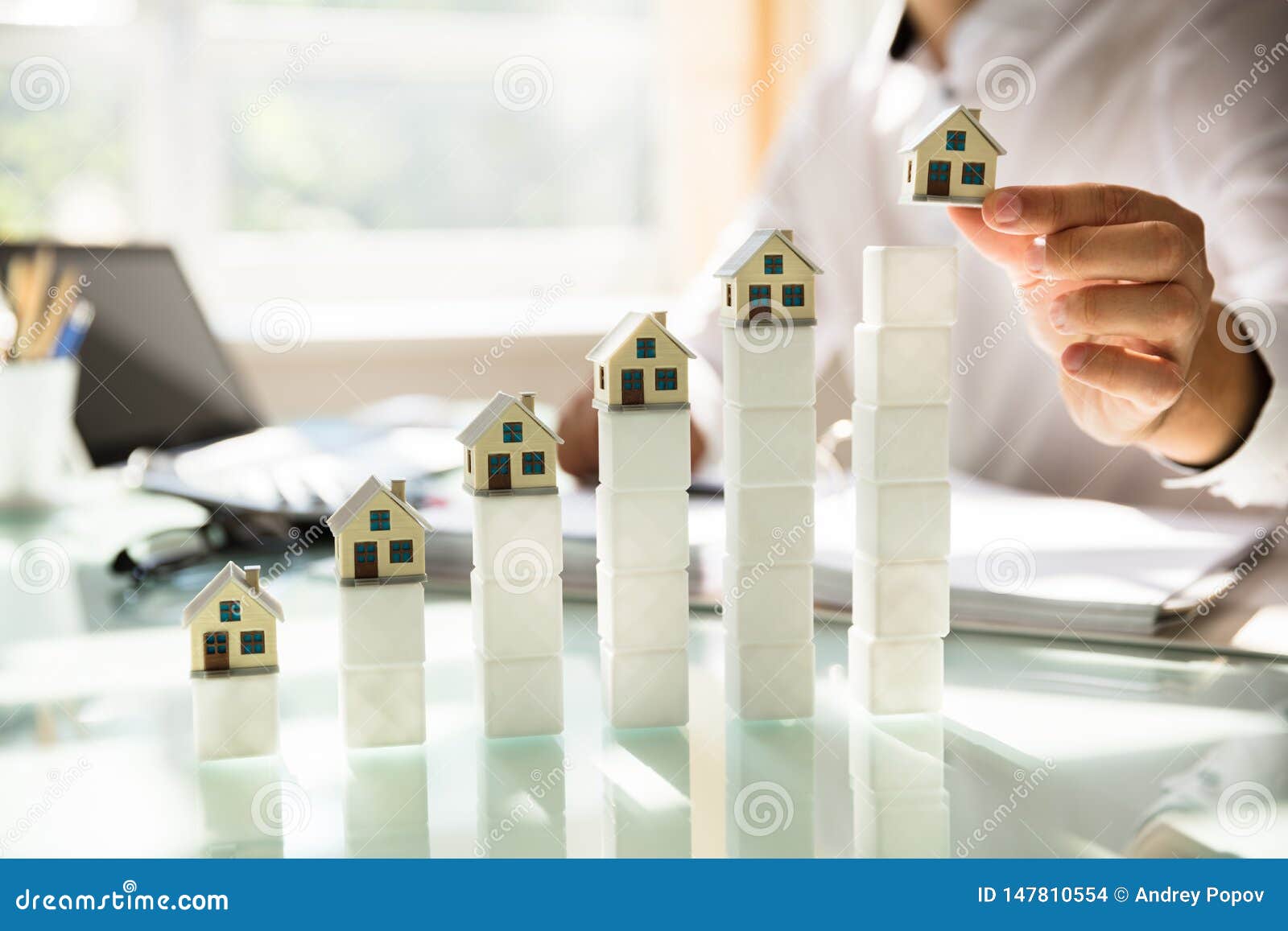 Increasing House Models on Reflective Desk Stock Photo - Image of ...
