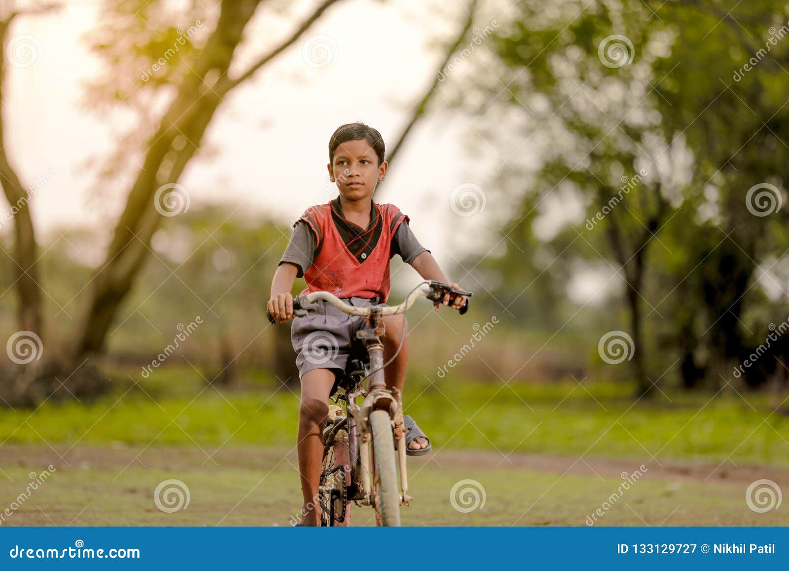 Indian child on bicycle stock image. Image of male, expression - 133129727