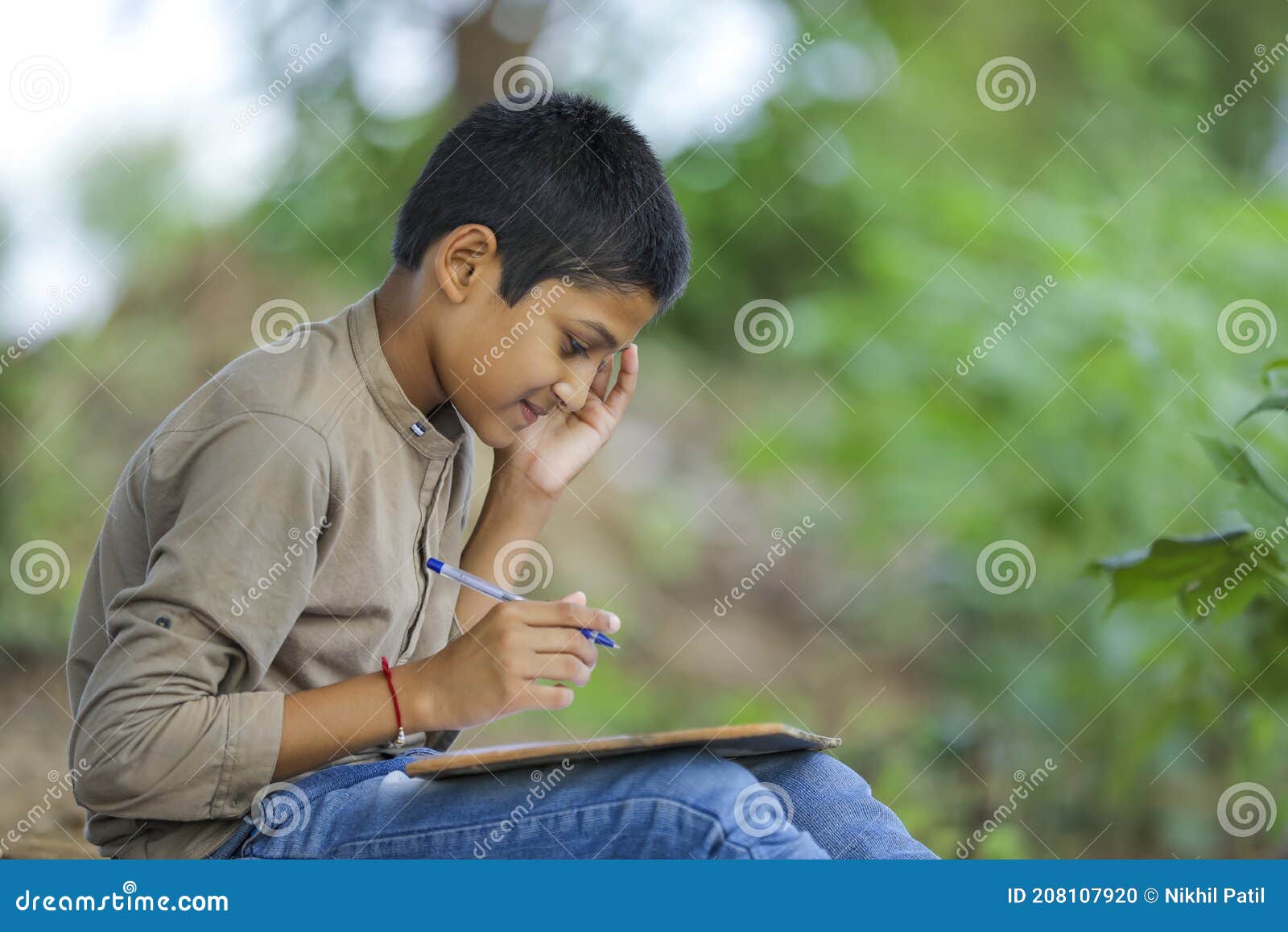 Indian Child Writing on Note Book Stock Photo - Image of outdoor ...