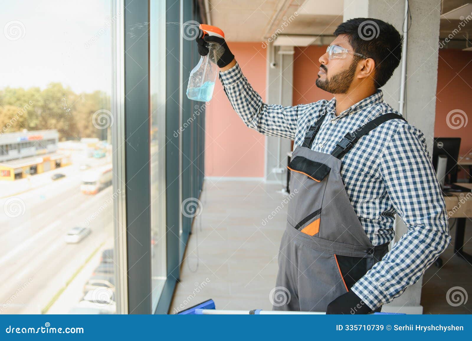 An Indian Cleaning Service Worker Washes Windows in an Office Building ...