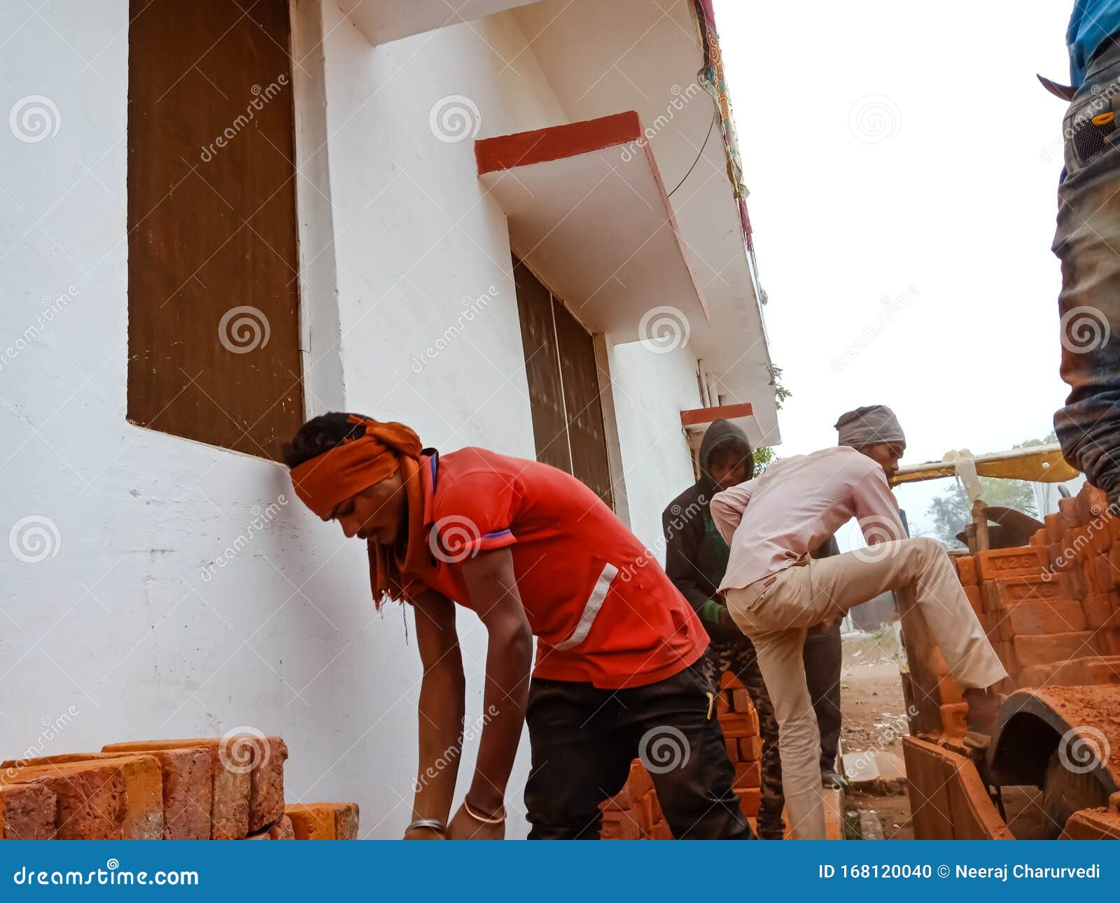Indian Construction Workers Unloading Bricks from Tractor at Site in ...